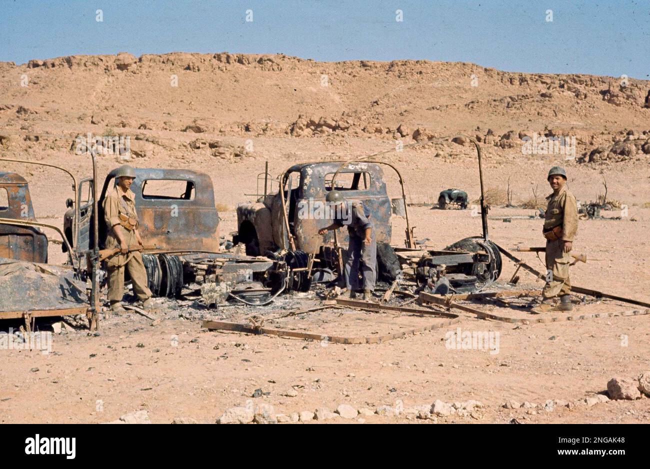 Soldiers mill around wrecked military vehicles at the Hassi Beida post ...