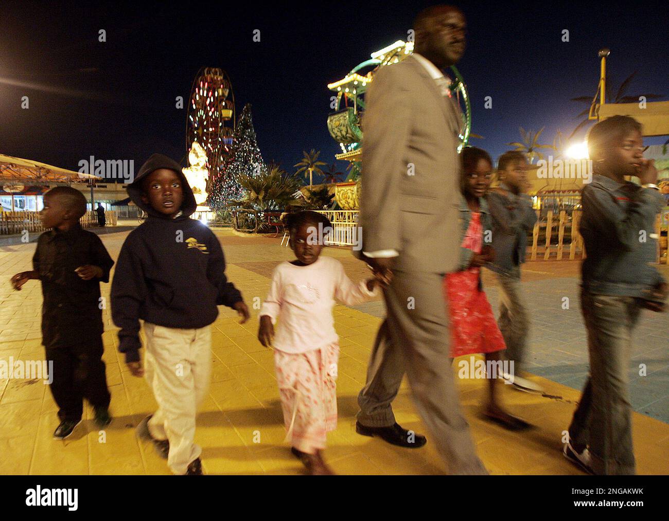 A family walks to the exit of the games park, Magic Land, in Dakar ...