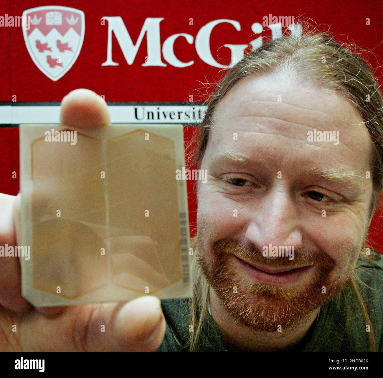 Dr. Ken Dewar holds the ultra-hi tech sequencing plate used to crack ...