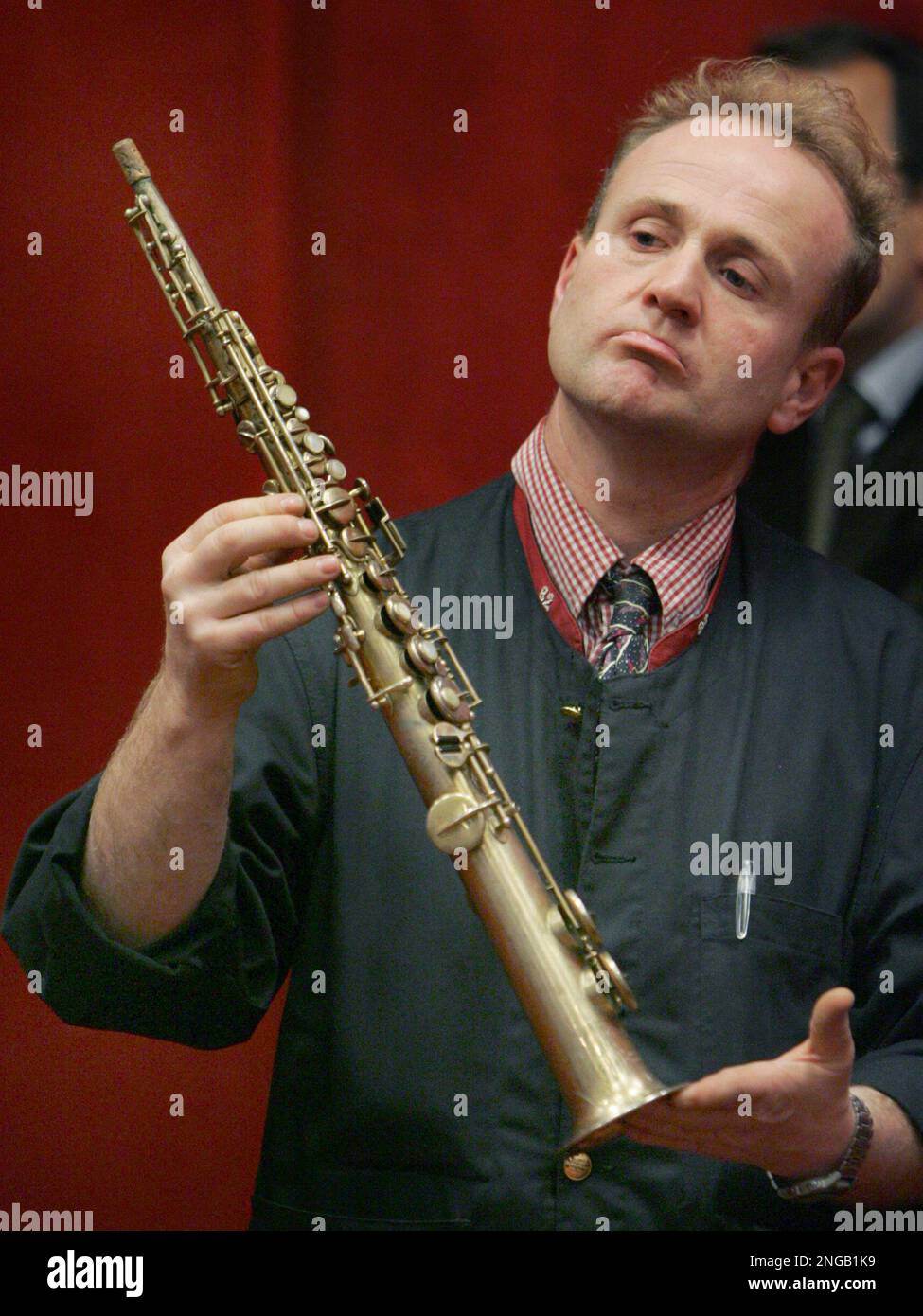 A Paris auction room employee holds the soprano saxophone of American ...