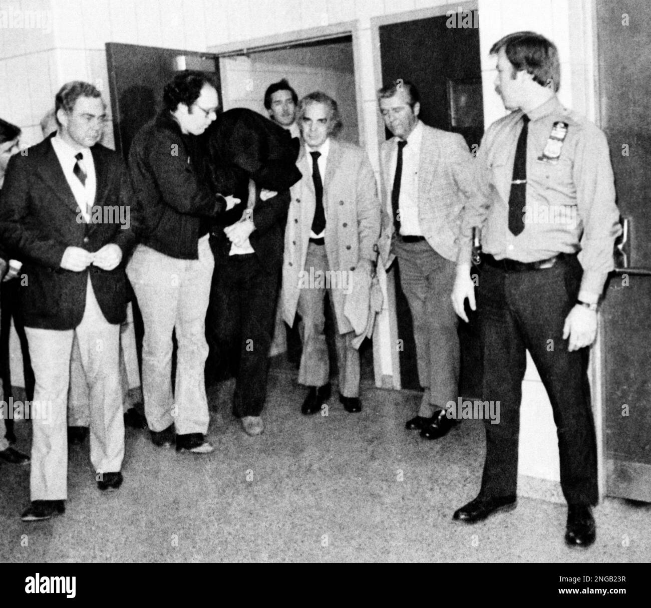 Police lead Mark David Chapman, head covered, from the 20th Precinct in ...