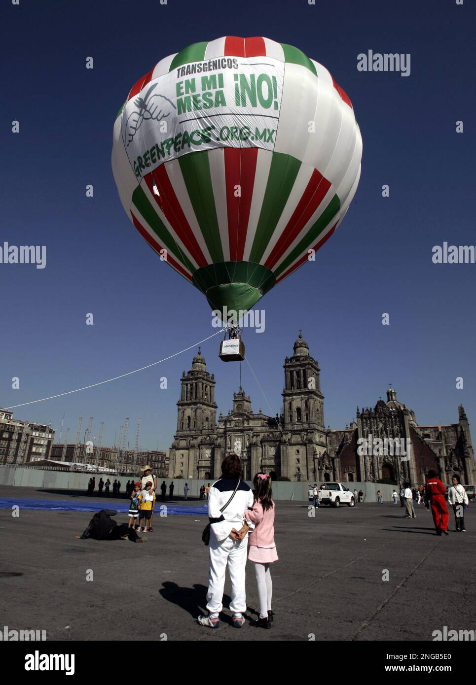 Passers-by look at a Greenpeace hot air balloon that reads "Transgenic ...