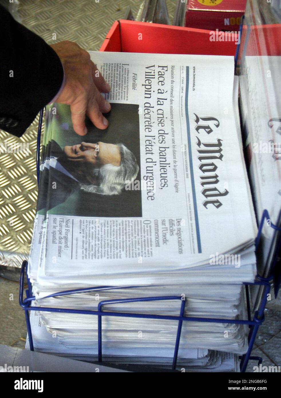 A customer buys the redesigned French daily newpaper Le Monde at a ...