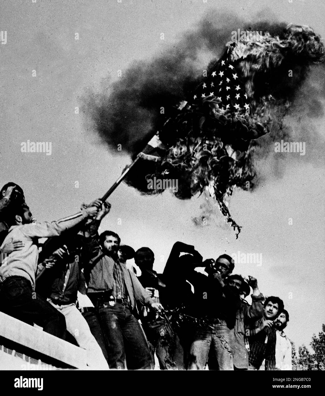 Demonstrators burn an American flag, Nov. 9, 1979, atop the wall of the ...