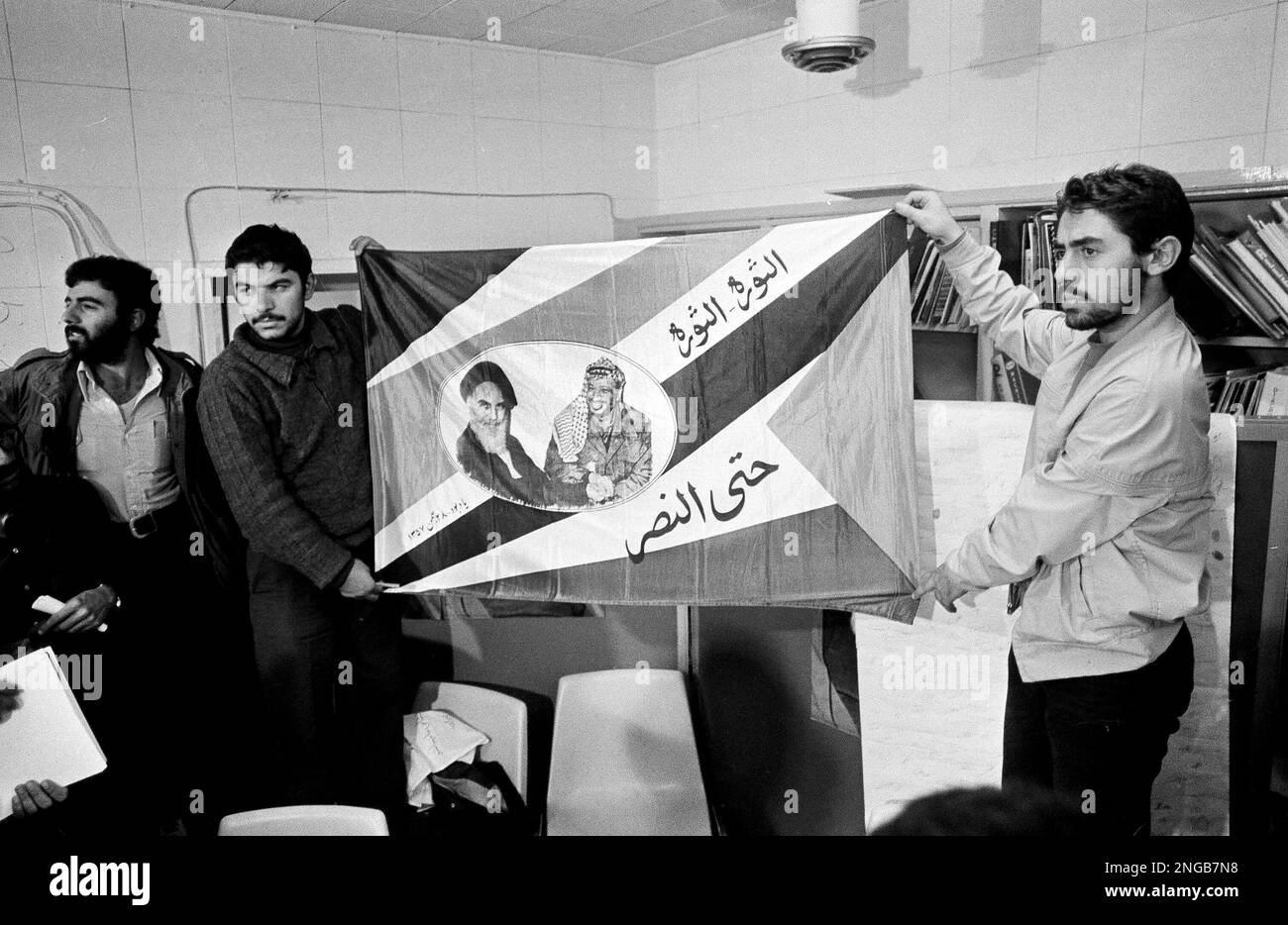 Two Iranian students display a flag showing Ayatollah Khomeini, left ...
