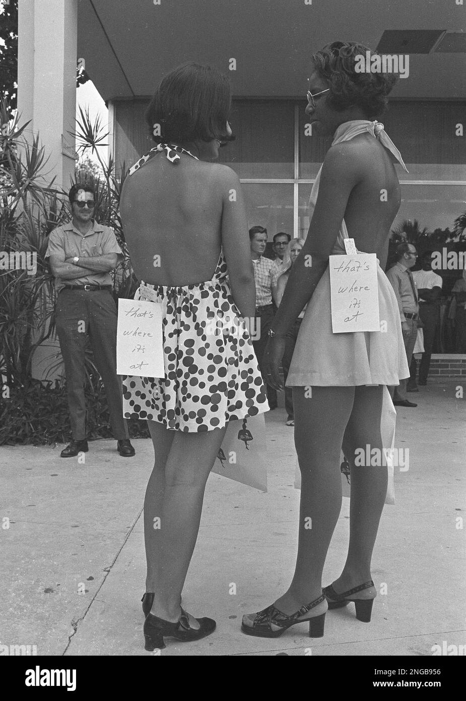 Mini-skirted women wear signs that read "That's where it's at," in ...