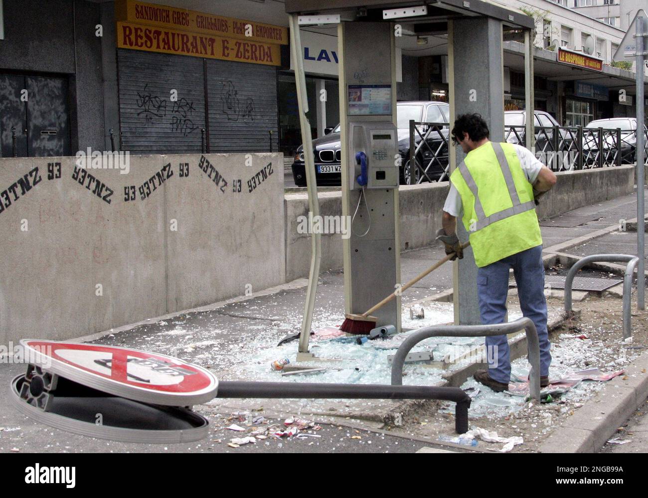 Janitor cleans a destroyed phone booth after riots erupted between ...
