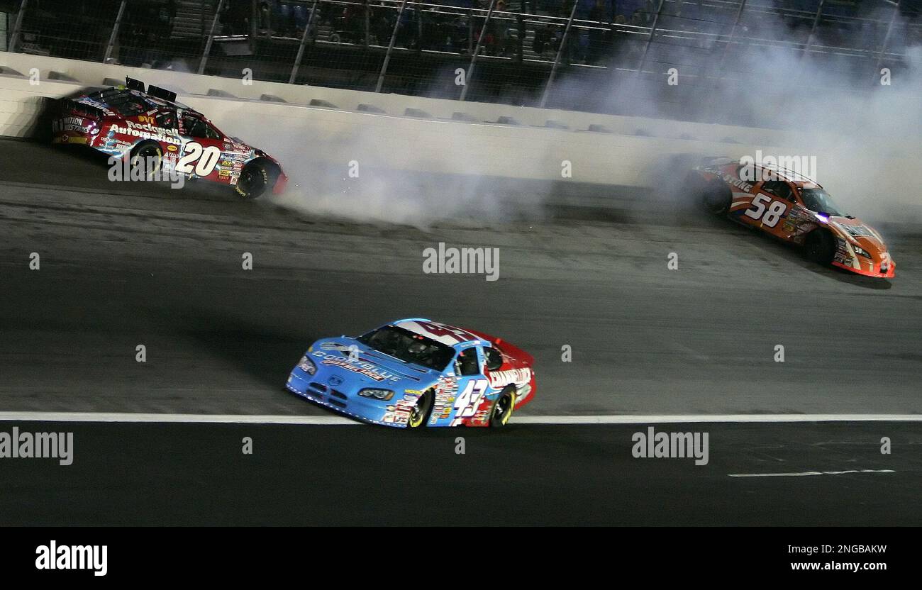 Denny Hamlin (20) and Regan Smith (58) spin in turn four as Aaron Fike ...