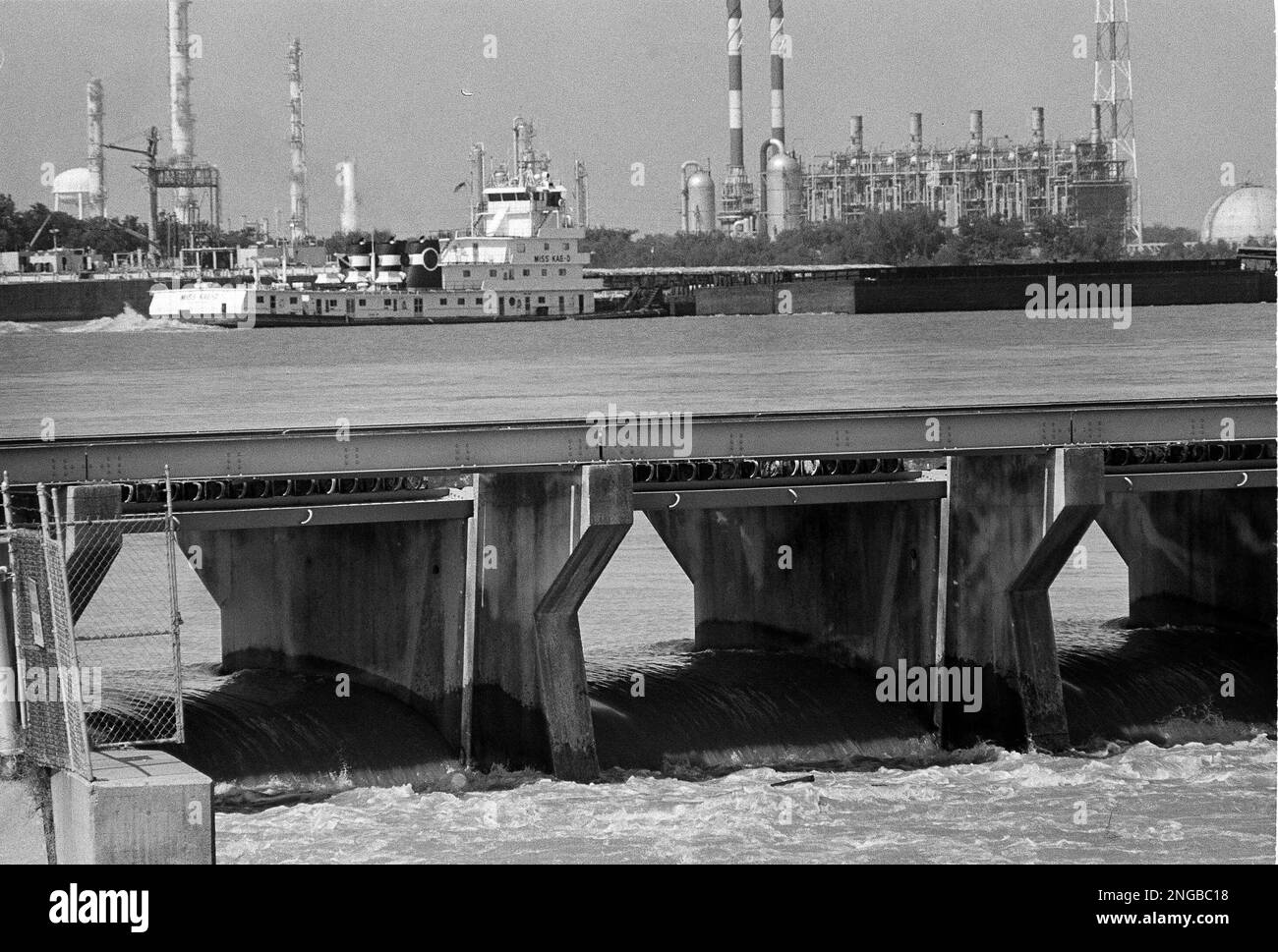 A tugboat pushes a barge up the Mississippi River as waters flow ...