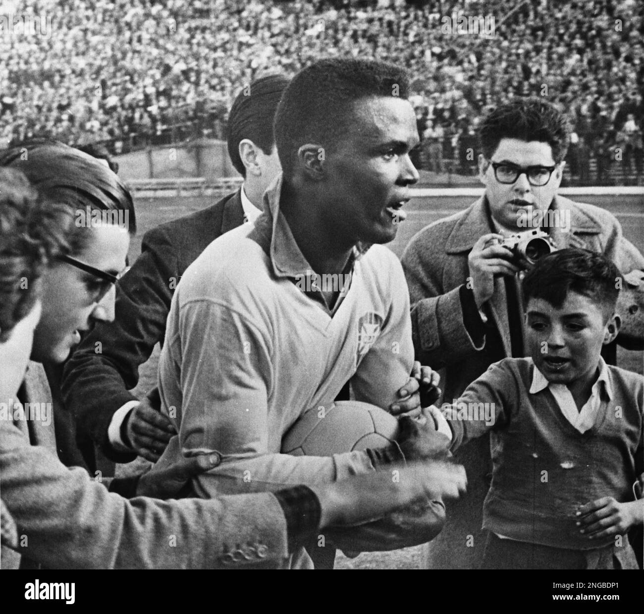 Brazilian player Zozimo keeps a tight hold on the ball as fans attempt ...