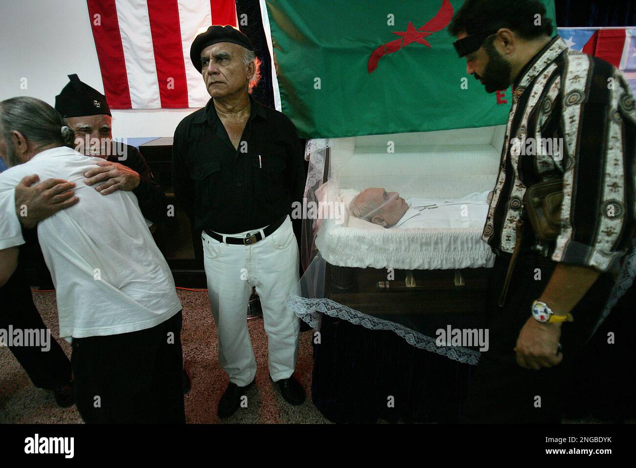 A man hugs one of the symbolic honorary guardsmen who stands over the ...