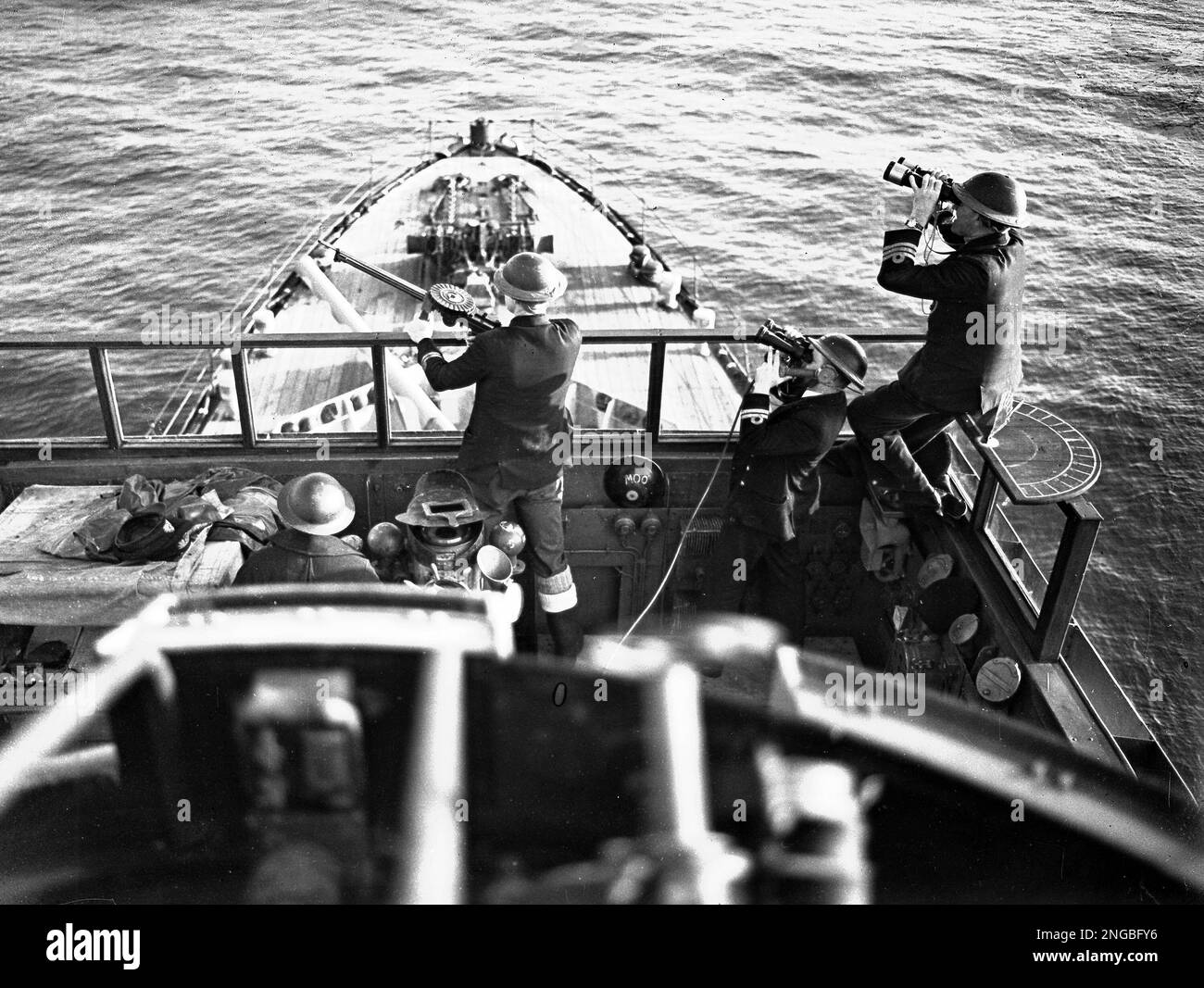 Royal Navy officers scrutinise an approaching aircraft on the bridge of ...