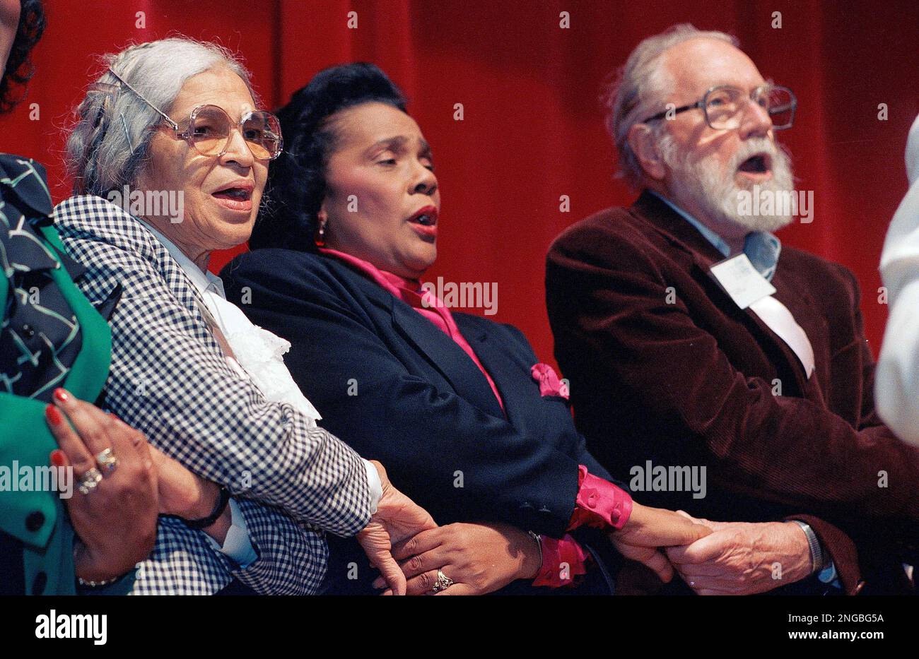 Rosa Parks, left, joins hands and sings with Coretta Scott King, widow ...