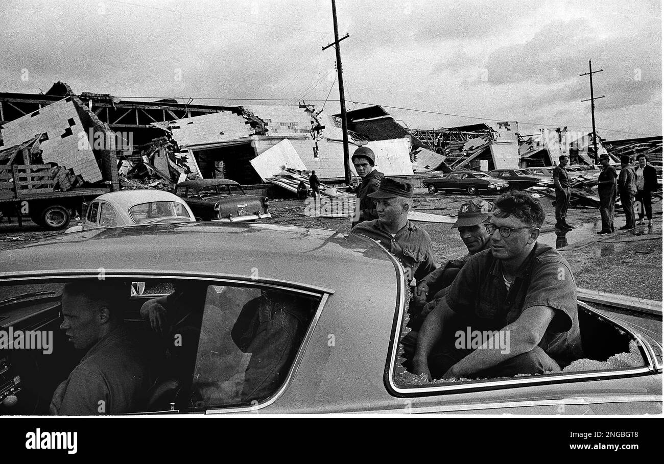 Three U.S. Marines sit in the broken window of a car in Gulfport, Miss ...