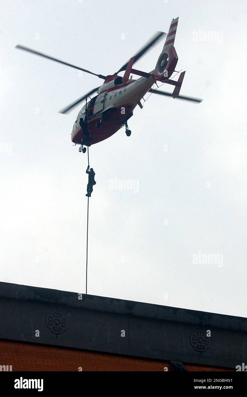 Taiwanese SWAT team members rappel down from a helicopter onto the roof ...
