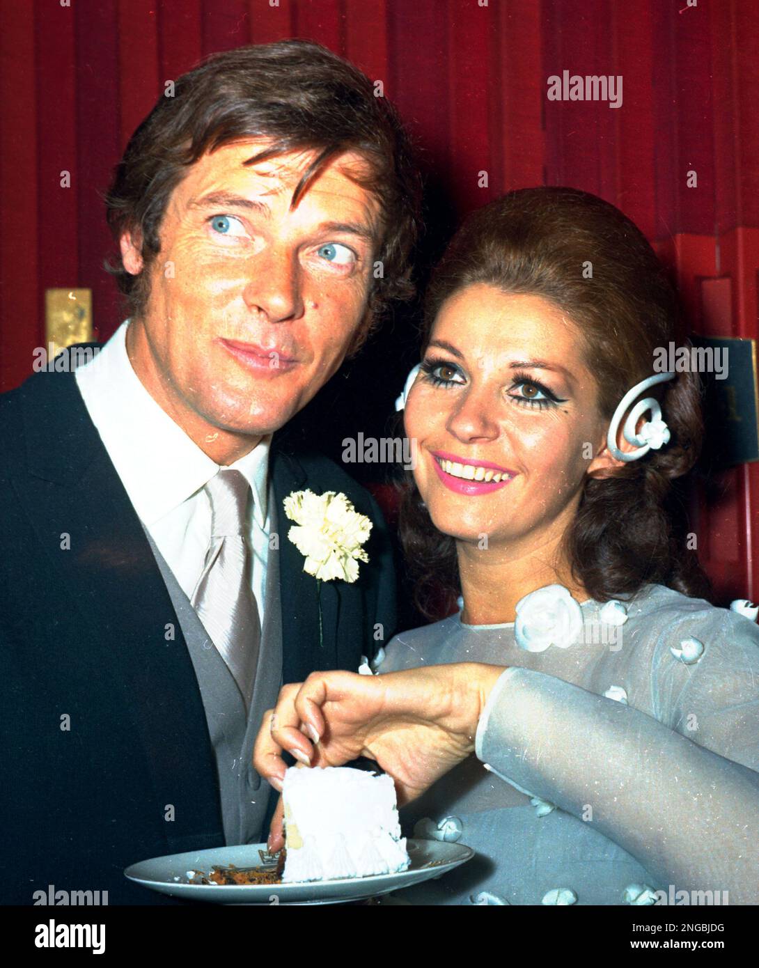 British actor Roger Moore shares a piece of wedding cake with his bride ...