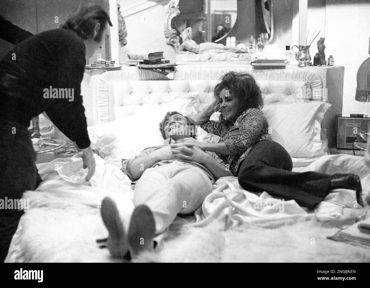 Michael Caine and Elizabeth Taylor relax on a bed during the filming of ...
