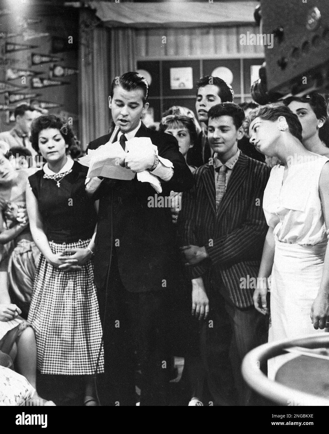 Television disc jockey Dick Clark is seen surrounded by teen age fans ...