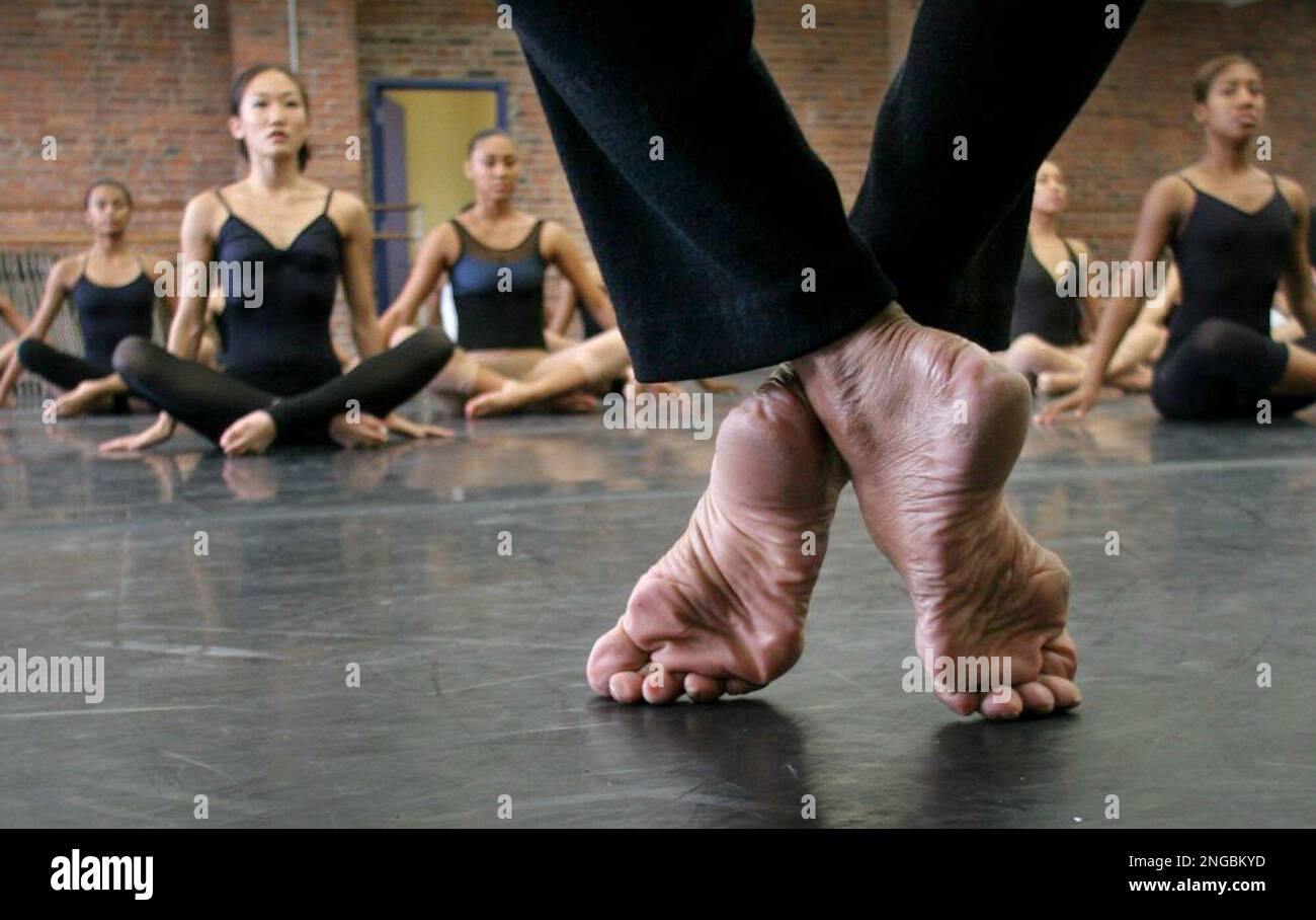 Guest teacher Mary Hinkson relax her feet while seated, as she ...
