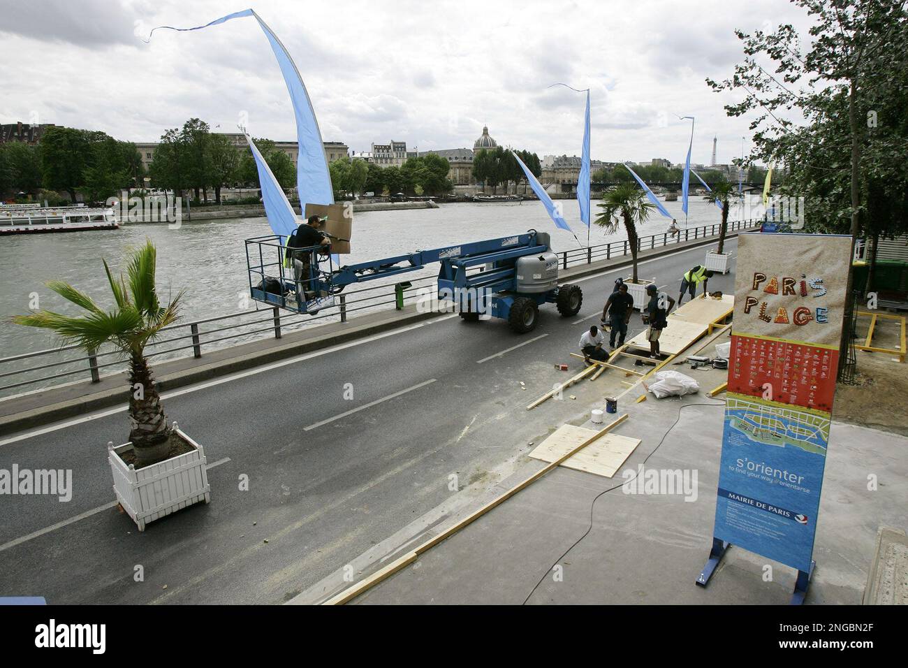 Workers prepare the Paris Beach installation along the Seine river ...