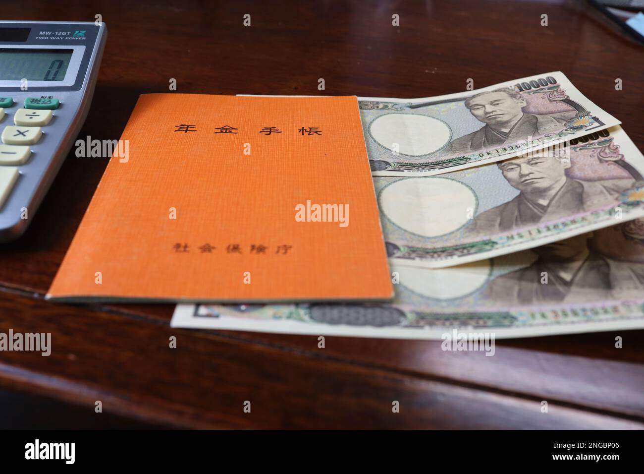 February 2023, Tokyo, Japan.Japanese pension book and cash on the table ...