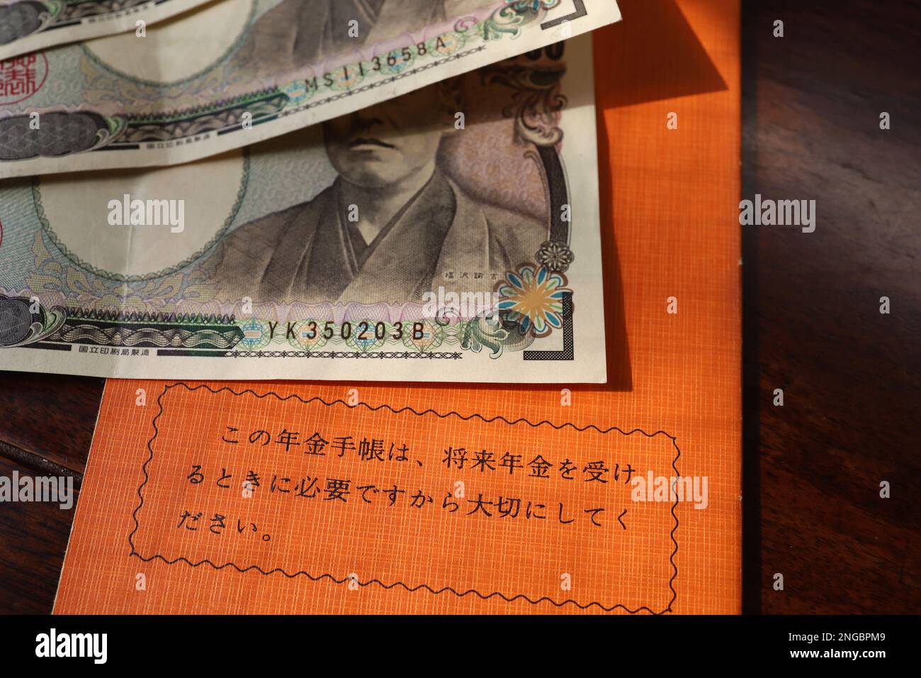 February 2023, Tokyo, Japan.Japanese pension book and cash on the table ...