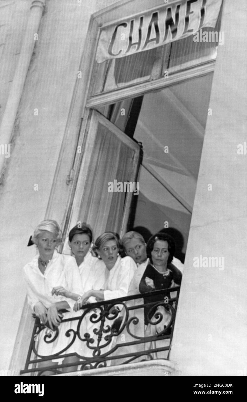 Fashion models lean out a window to take a look at the people attending ...