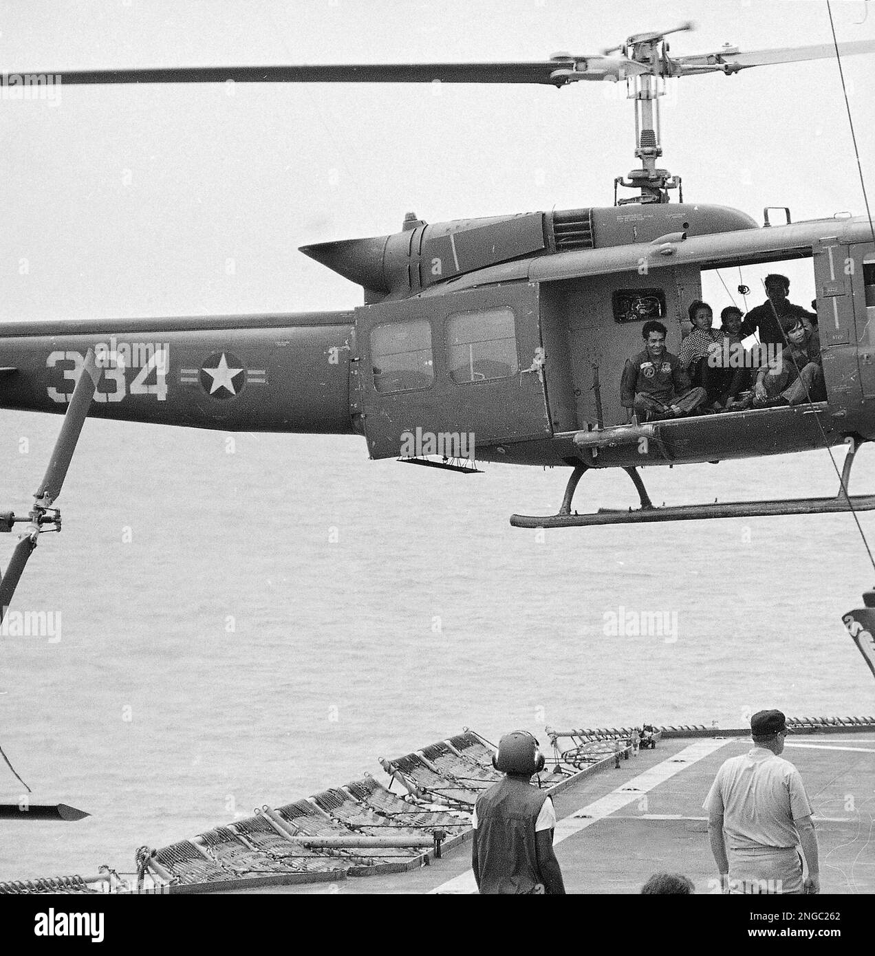 A helicopter loaded with refugees from South Vietnam lands aboard the ...