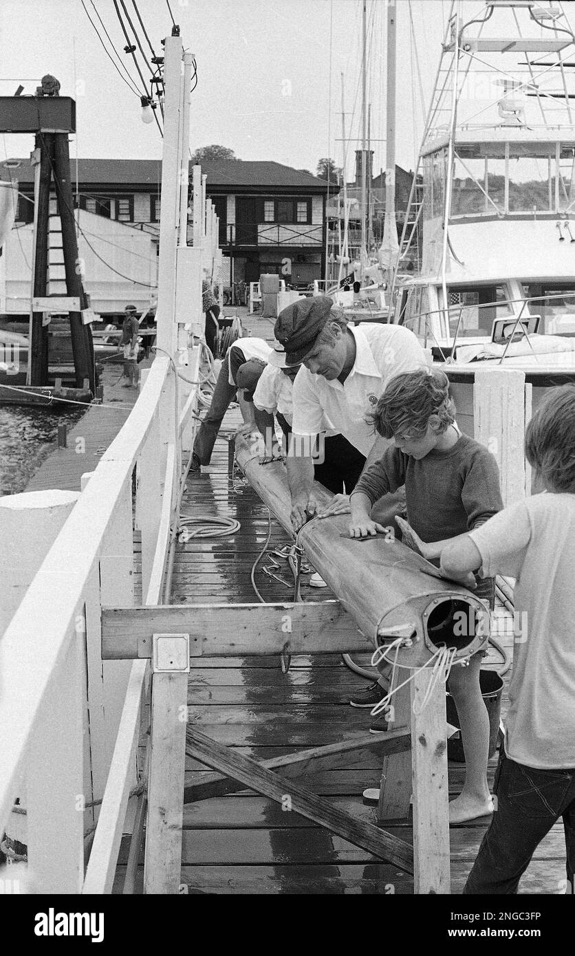 Ted Turner gets a helping hand from his son Rhett, 11, sanding the boom ...