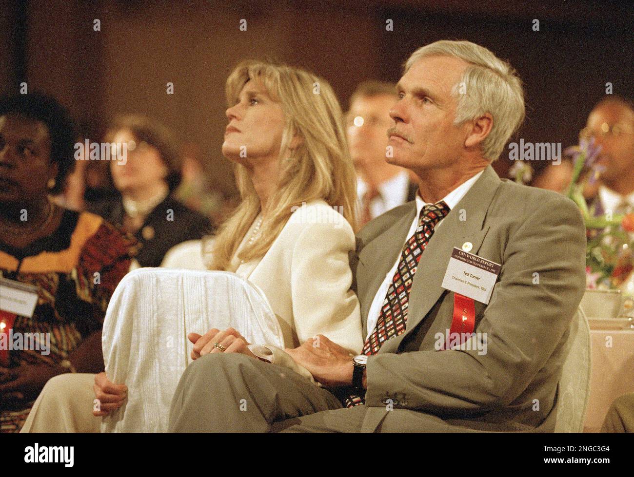 Ted Turner and his wife, Jane Fonda, hold hands as they listen to First ...