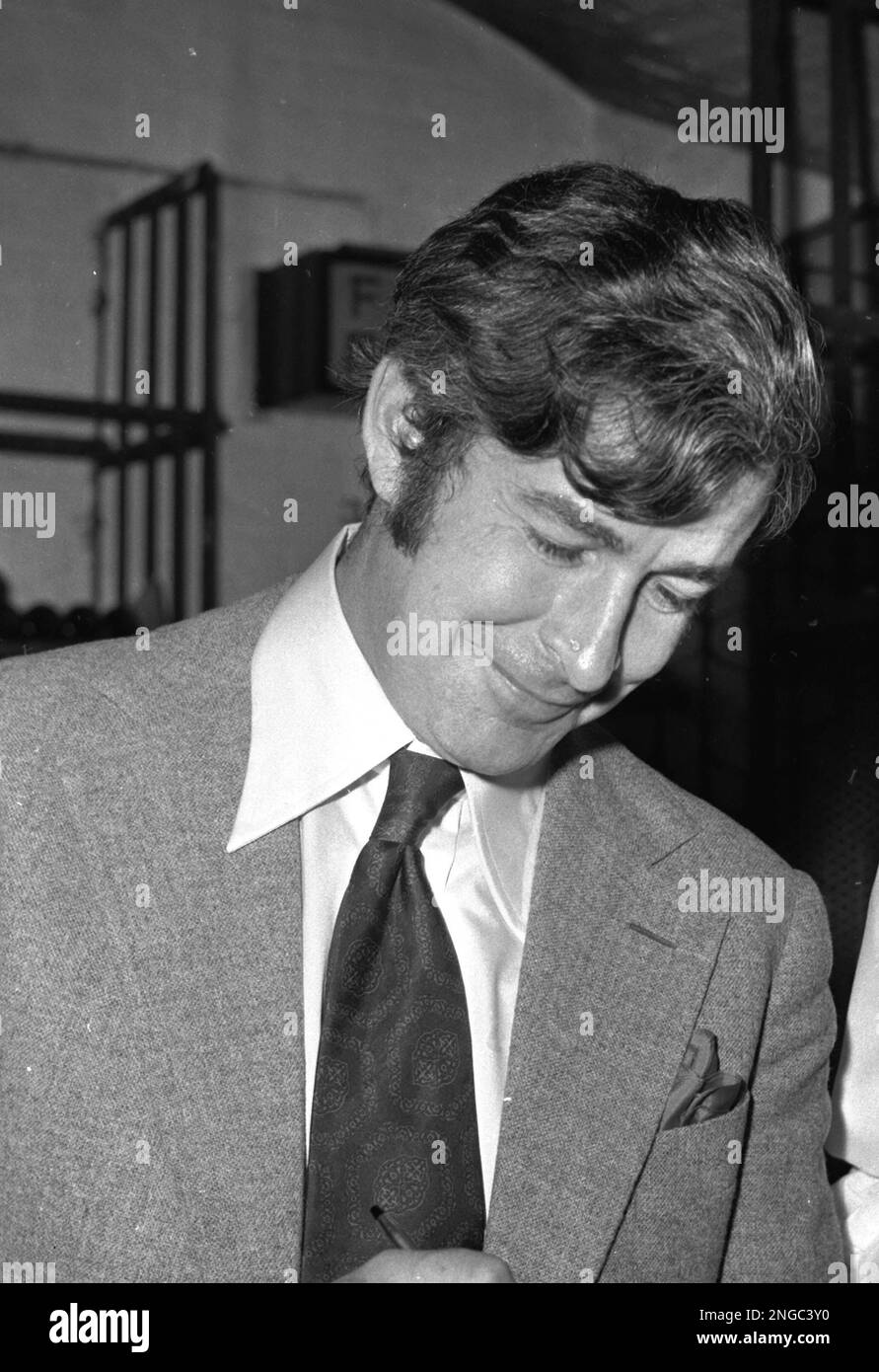 Irish comedian Dave Allen, signs a copy of his book at a reception held ...