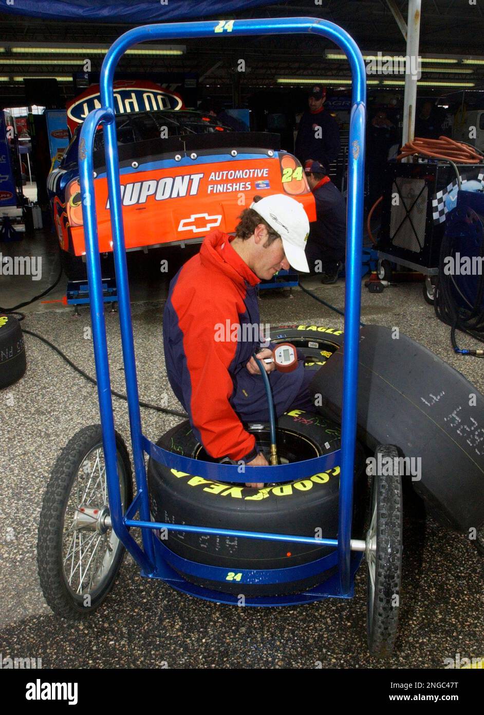 A tire man for Jeff Gordon checks air pressure during preparations for ...
