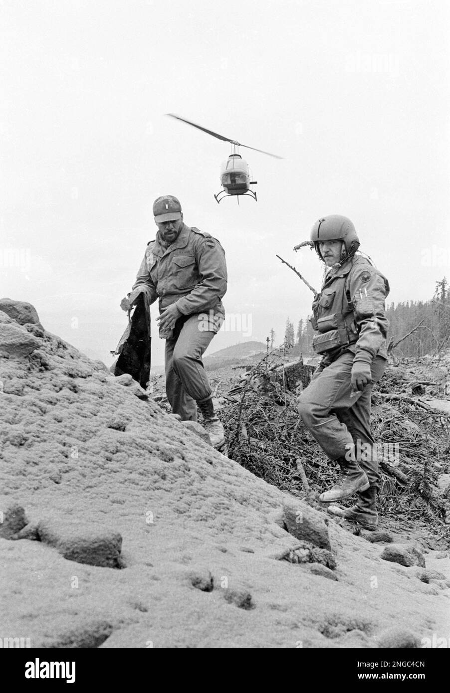 While an Army helicopter hovers overhead 2nd Lt. Von Roberts, left, and ...