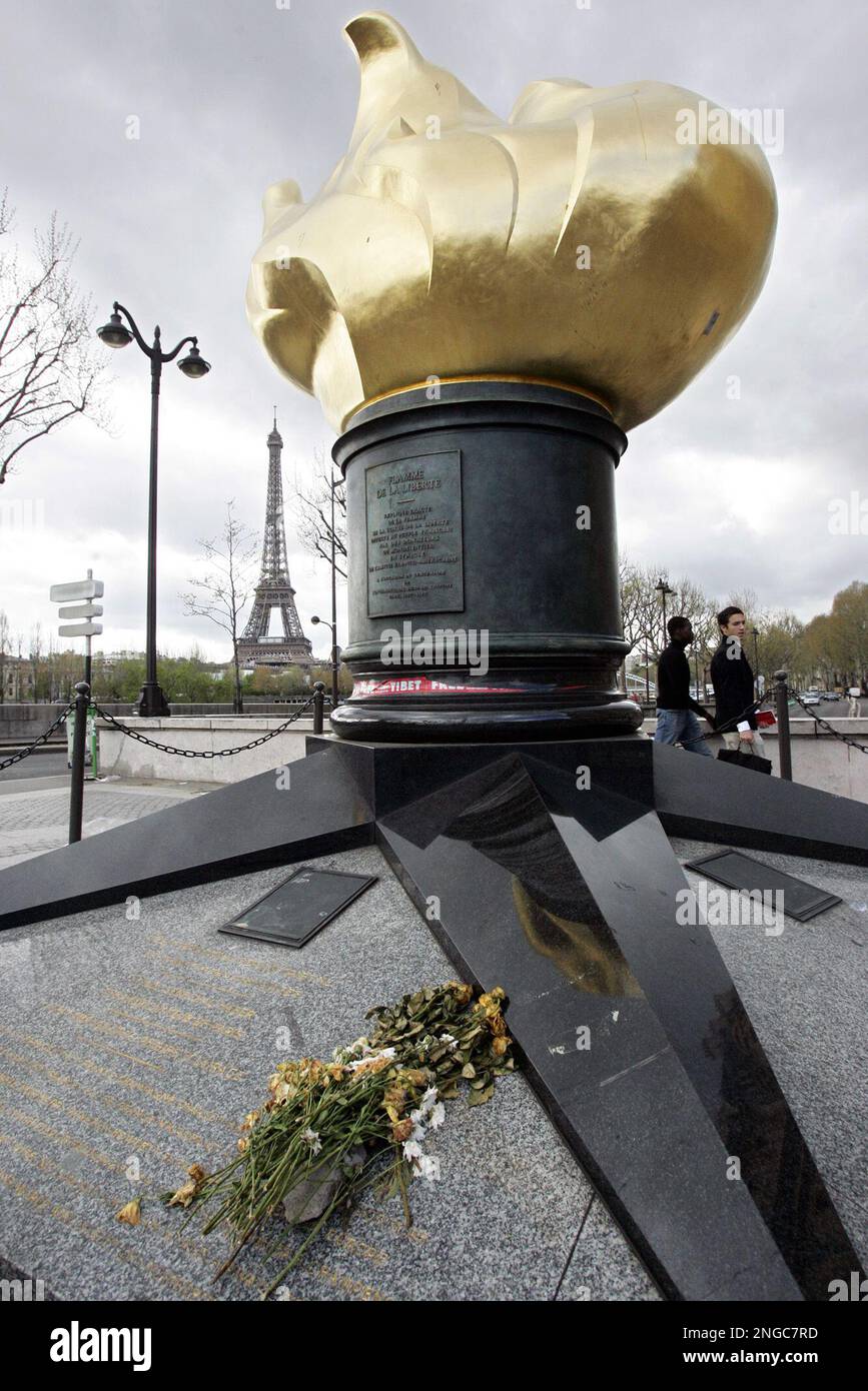 Flowers fade by the Flame of the Liberty monument where people have ...