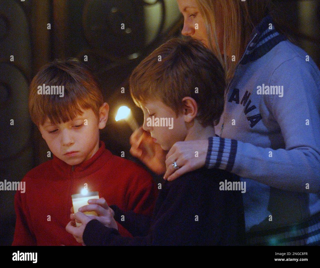Youngsters light candles at the Notre Dame Cathedral in Paris during a ...