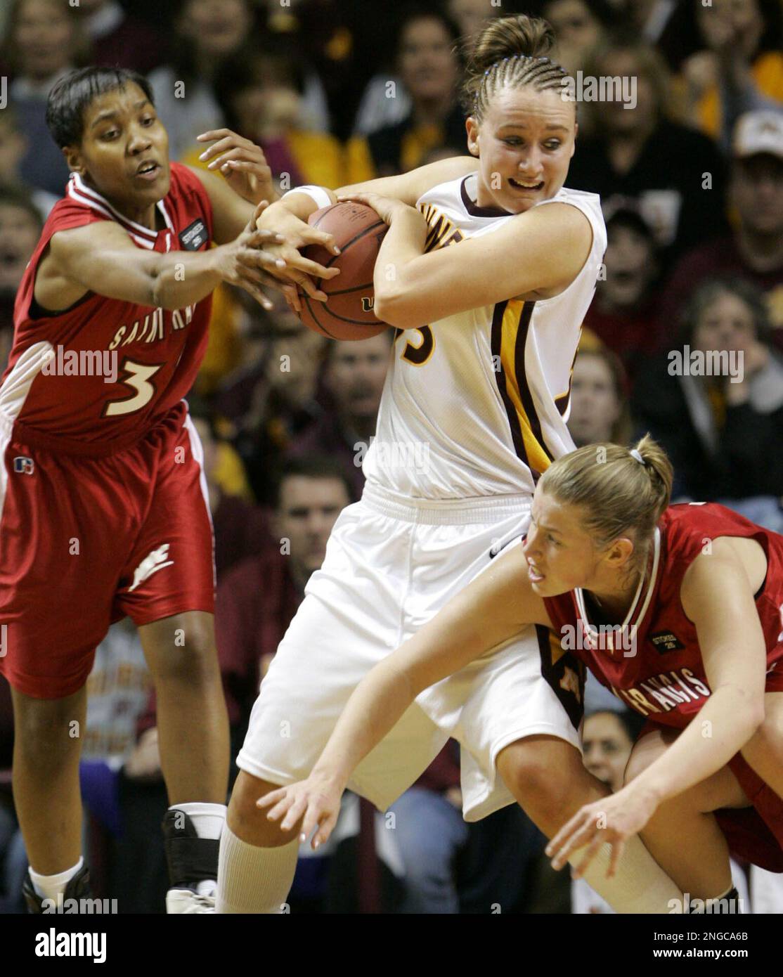 Minnesota forward Jamie Broback, center, wrestles the ball away from ...