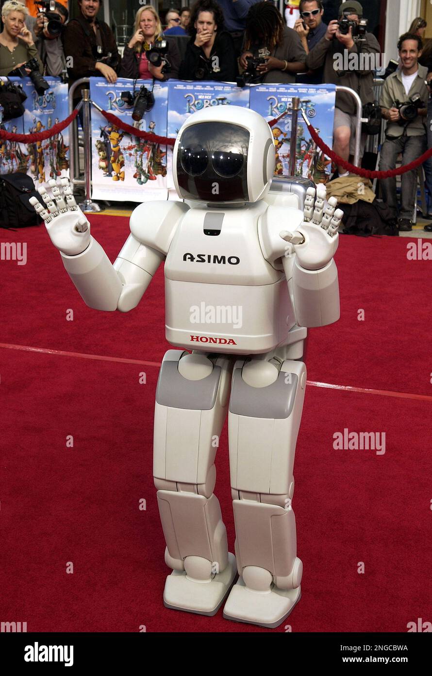 Honda Motor Co.'s walking robot, Asimo, waves to photographers at the premiere of "Robots ...