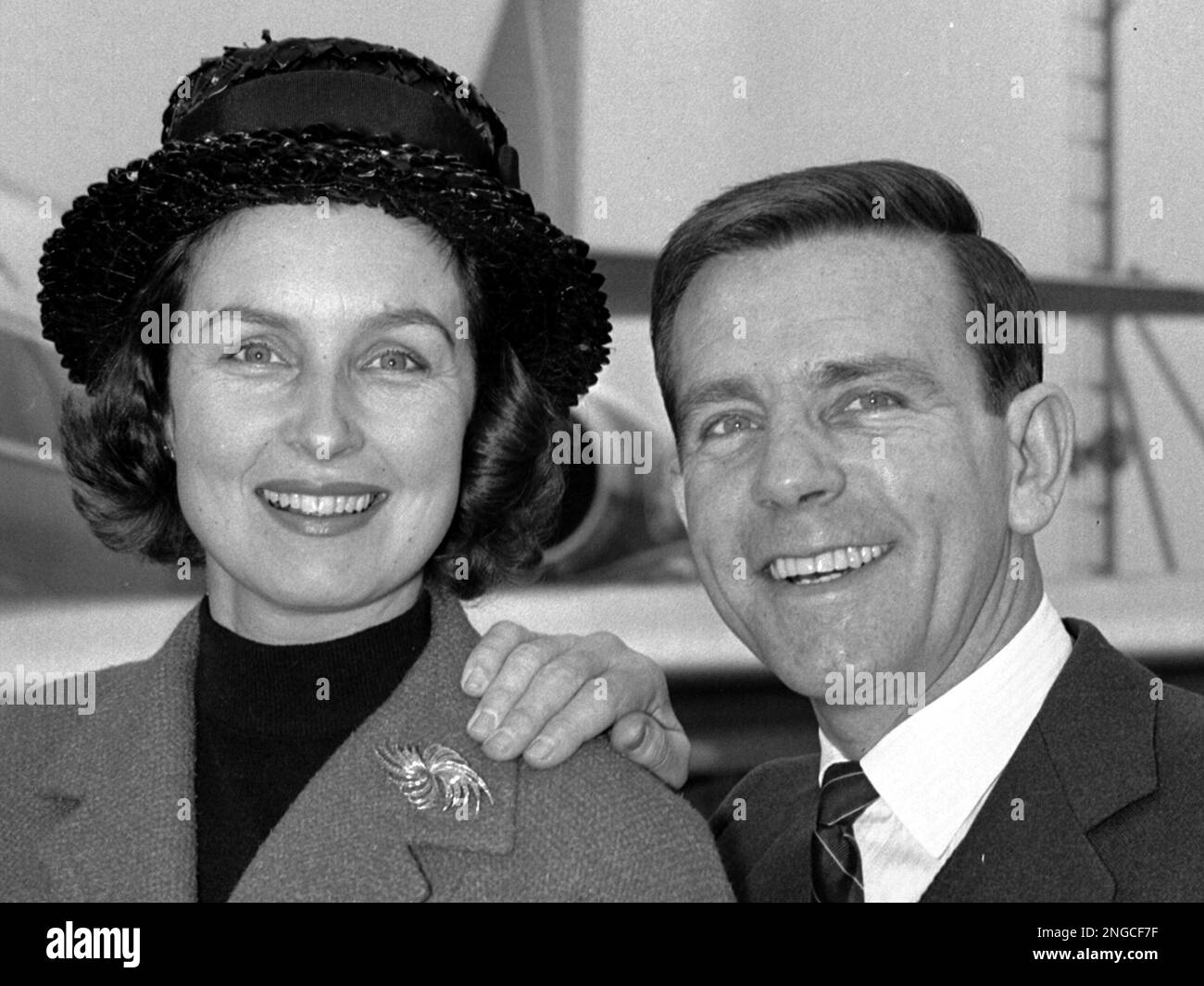 British comedian Norman Wisdom and his wife Freda smile before boarding ...