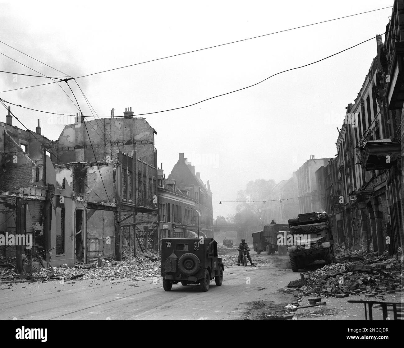 Allied armoured vehicles rumble past smouldering buildings in Arnhem ...
