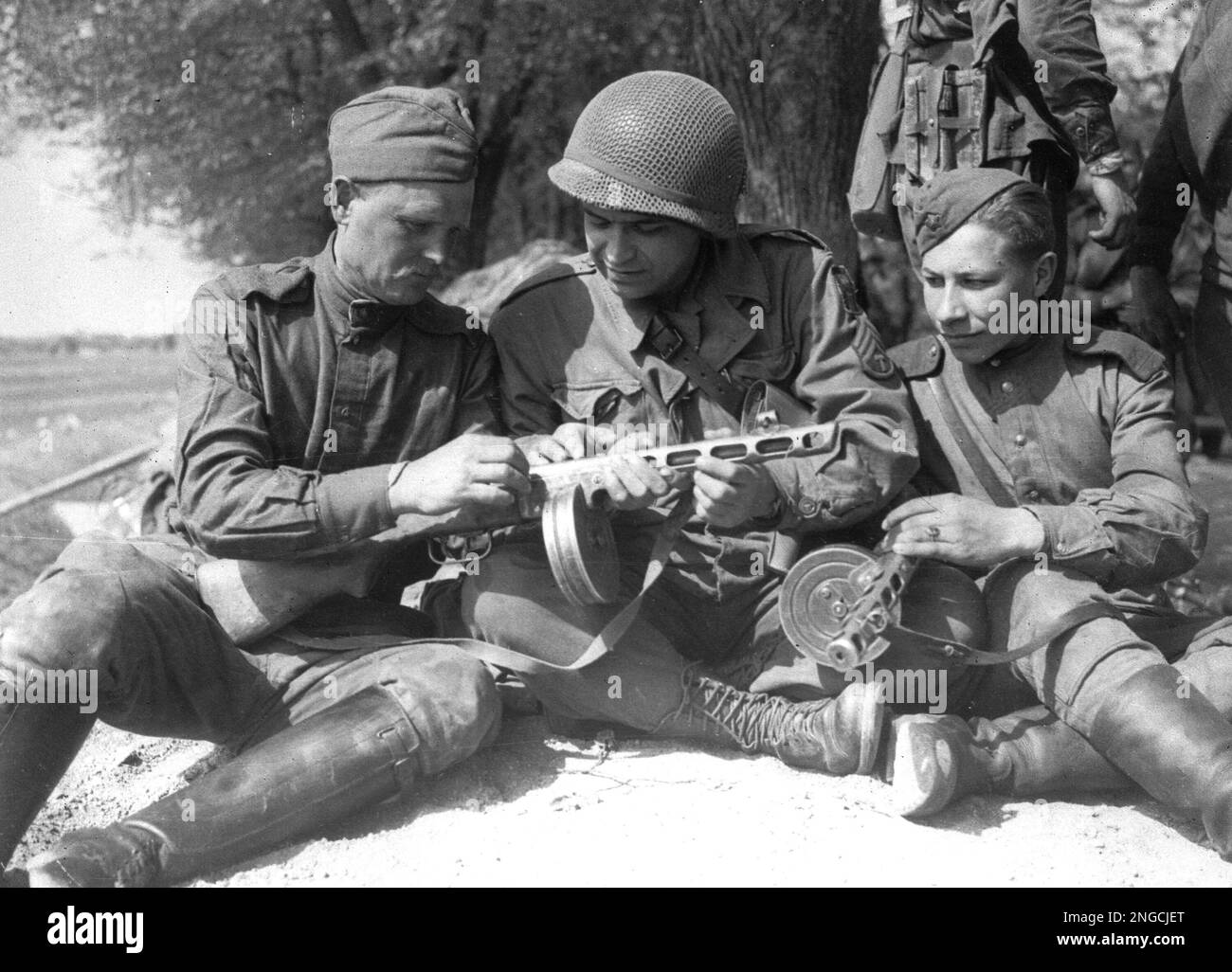 Two Soviet soldiers show a sergeant of the 1st U.S. Army the Red Army ...