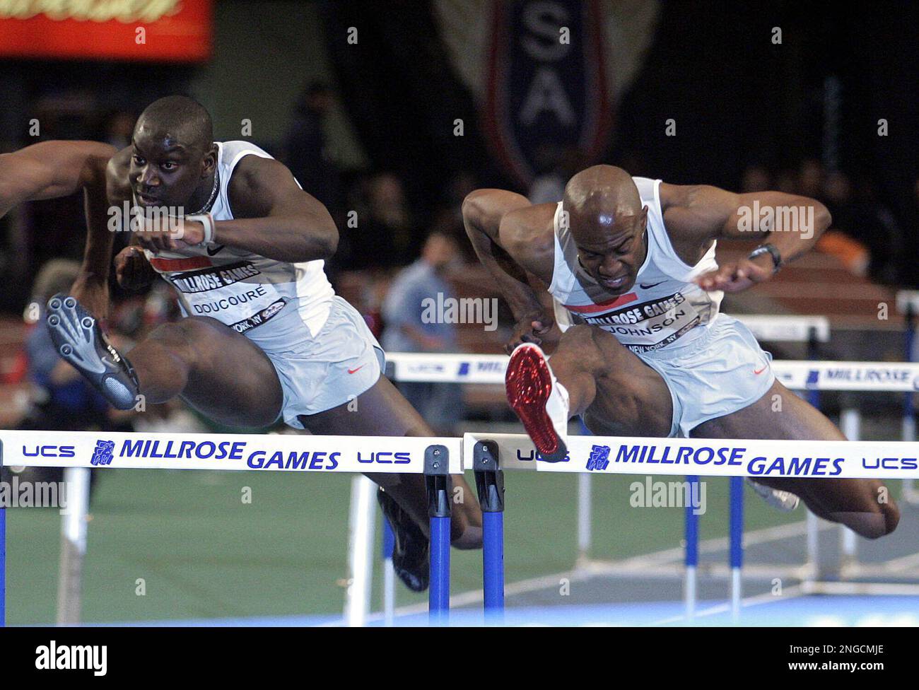Allen Johnson, right, leaps a hurdle in time with Ladji Doucoure during ...