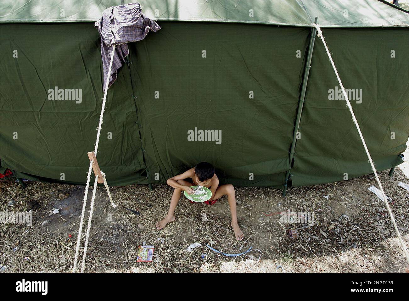 A homeless survivor boy has a lunch at a refugee camp in Banda Aceh ...