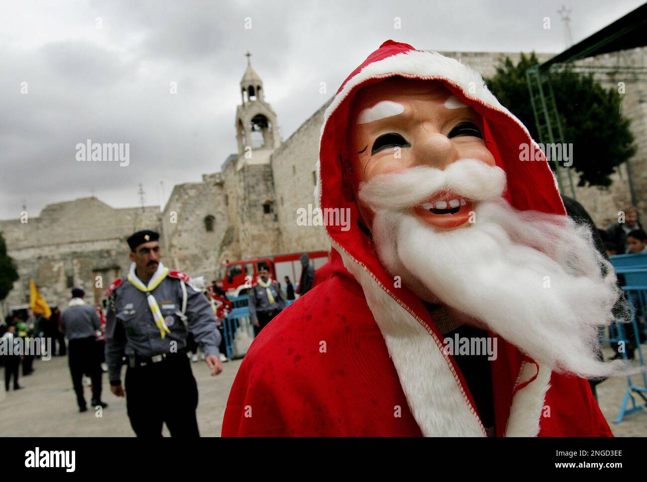 A Palestinian Christian dressed as Santa Claus stands outside the ...