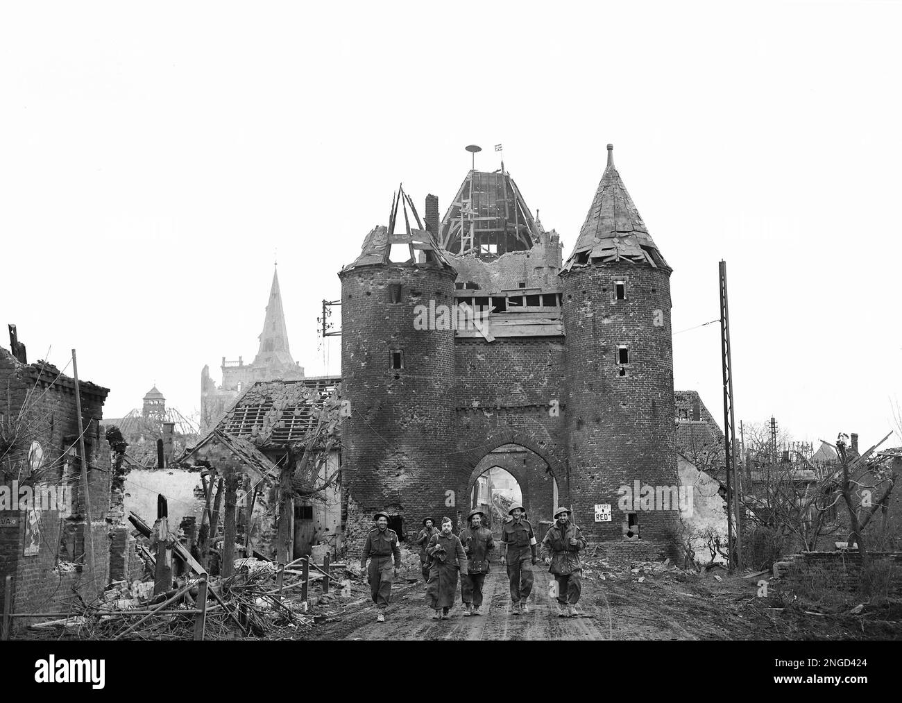 A German prisoner of war, escorted by British soldiers, is led out of ...