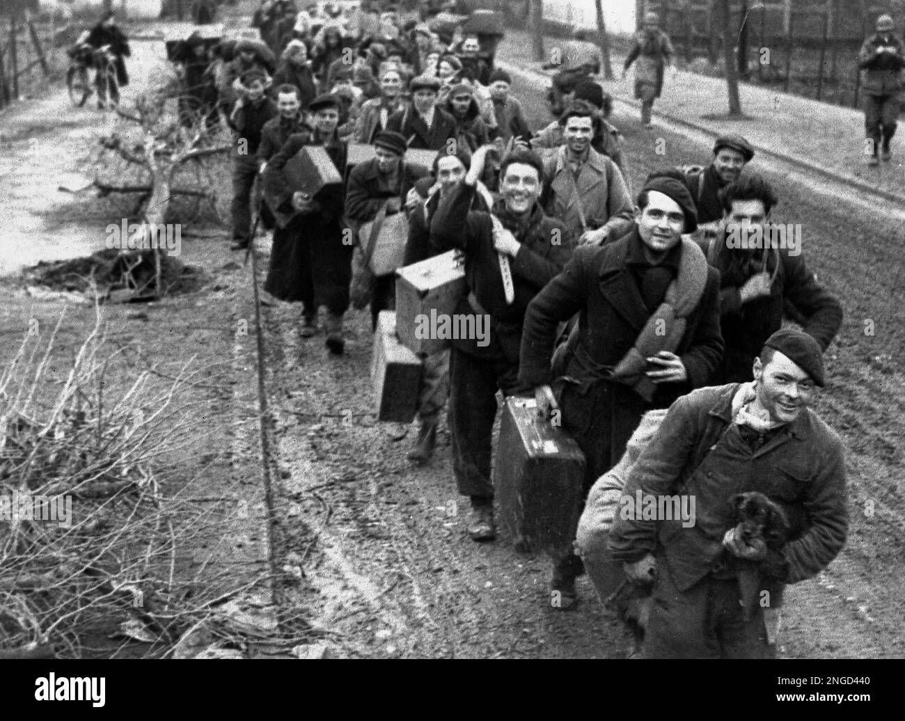 A smiling column of French civilians, carrying personal belongings ...