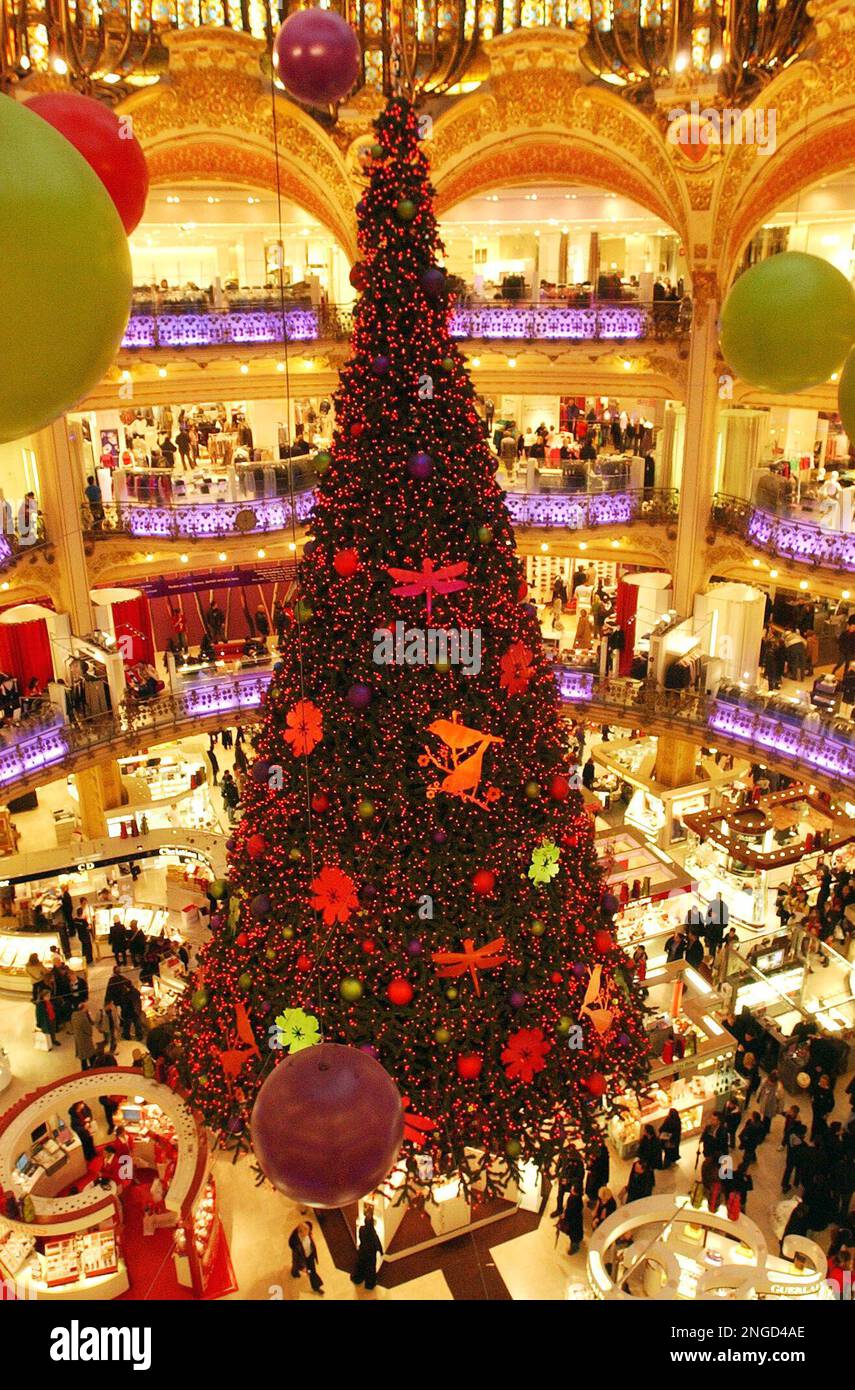 A giant Christmas tree is set up inside a Paris department store ...
