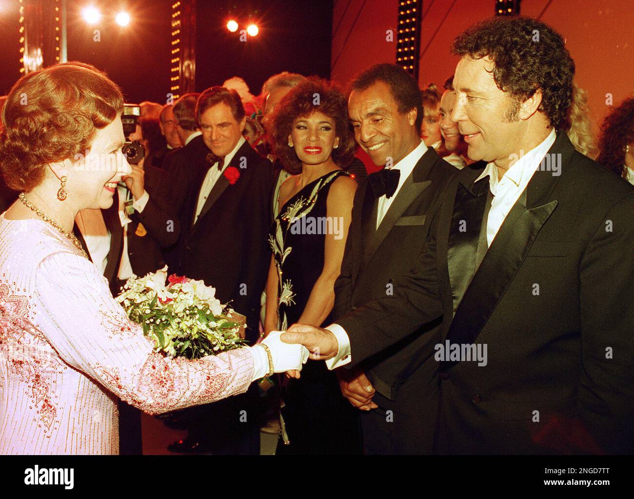 British singer Tom Jones, right, shakes hands with Britain's Queen ...