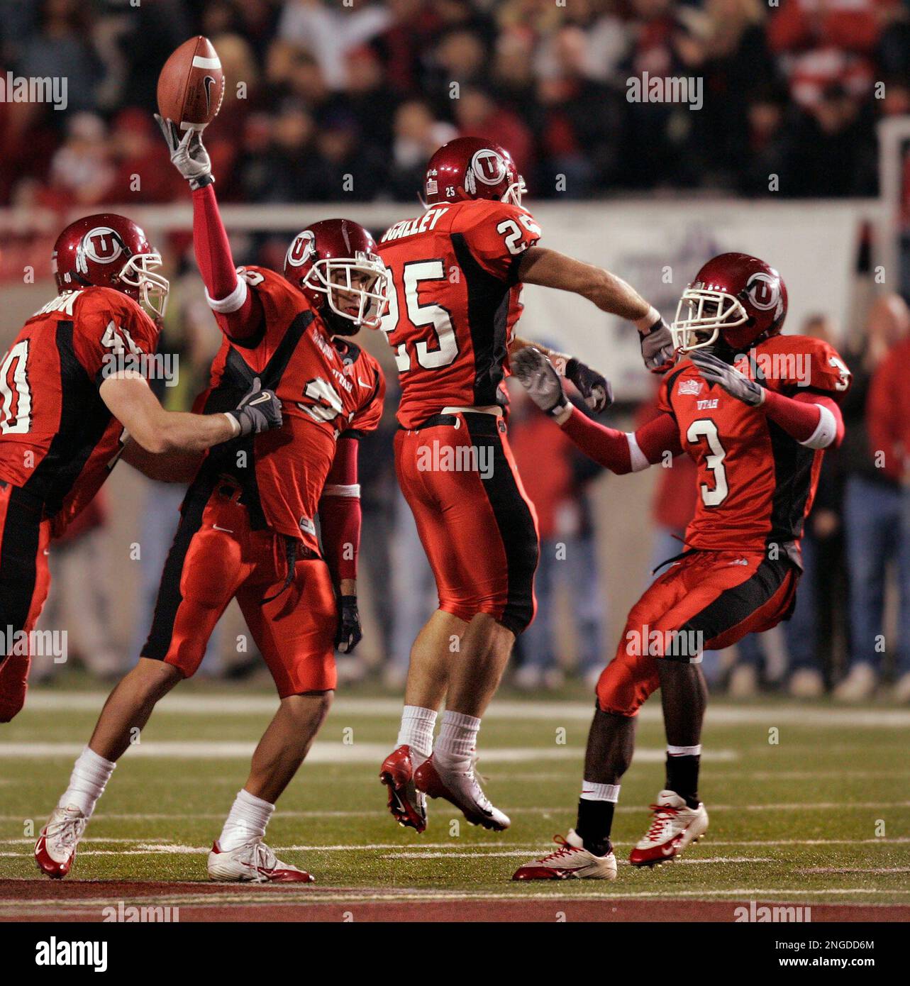 Utah defensive back Eric Weddle holds the ball high as he and teammates ...