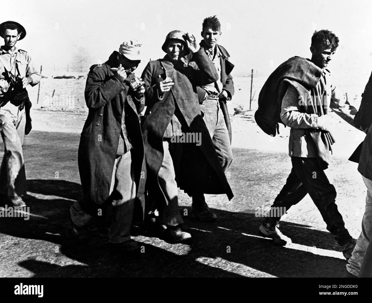 A hungry German soldier eats as he marches to a prisoner of war ...