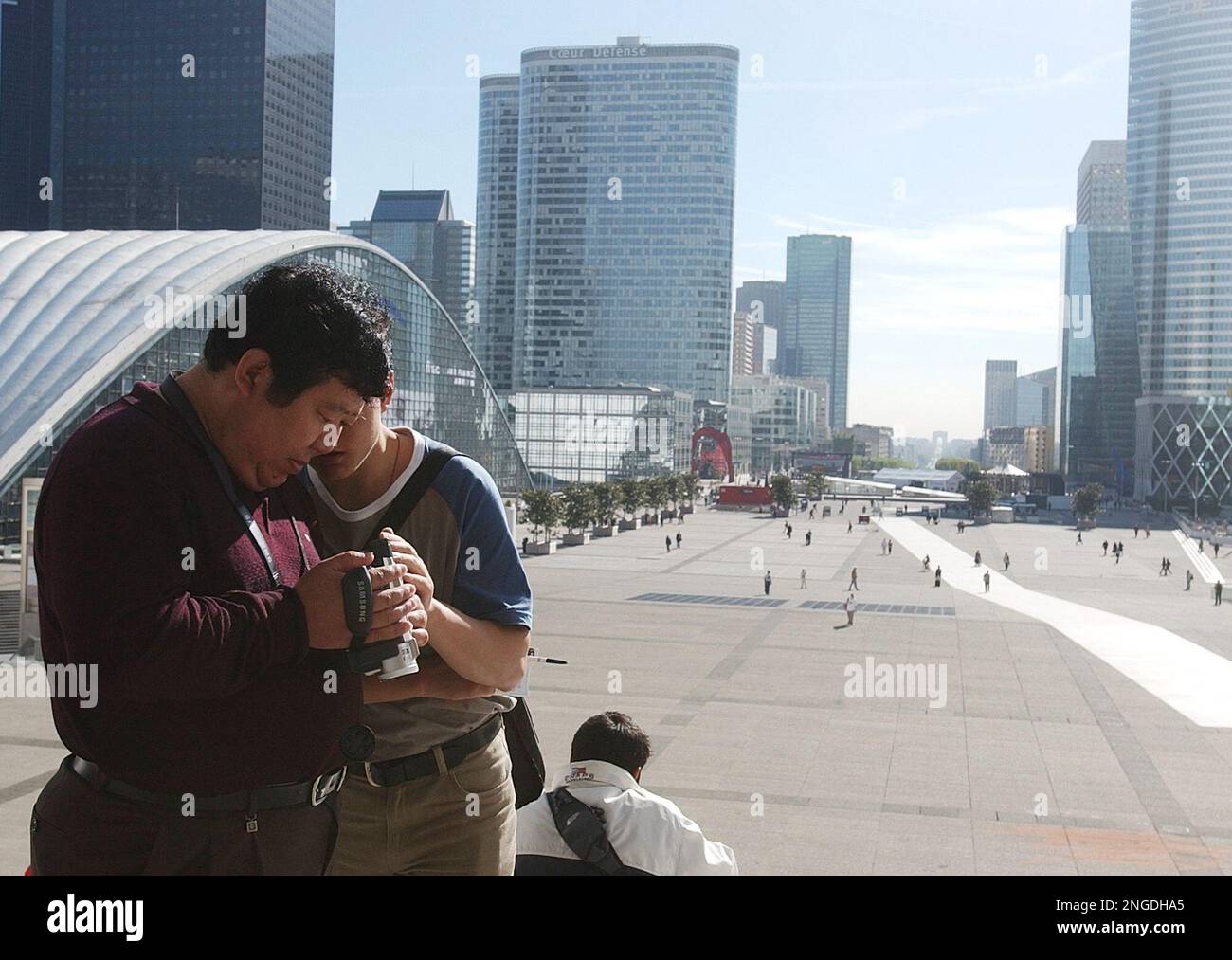 Chinese tourists check a video in Paris suburb La Defense, Sept.17 ...